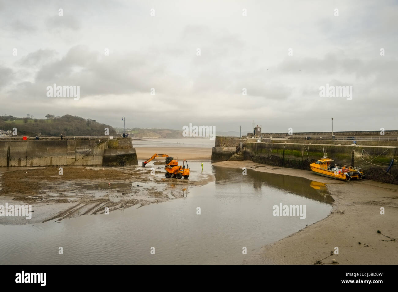 Saundersfoot Harbour maintenance. Heavy plant machinery assist in ...