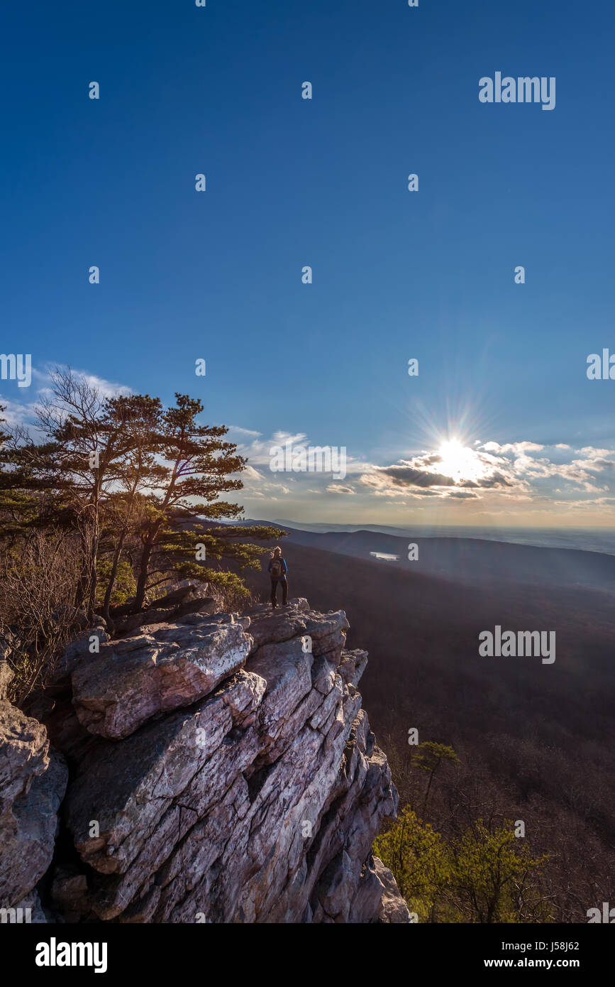 Female hiker standing at the edge of a rocky cliff on an Appalachian ...