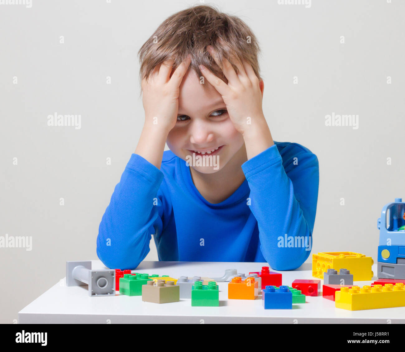 Little kid boy playing with colorful plastic construction bricks at ...