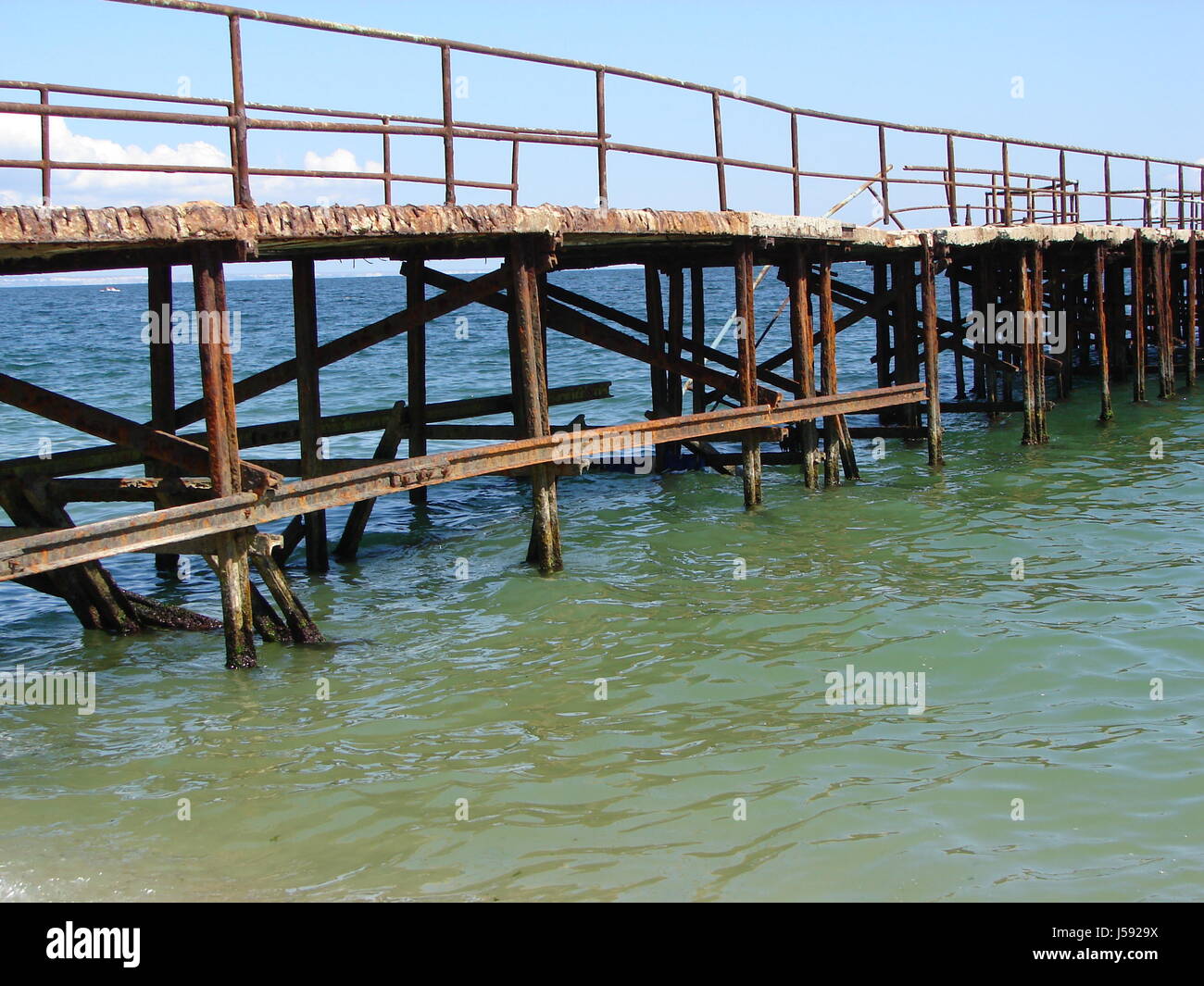 bridge iron rusty rust railing firmament sky salt water sea ocean water ...