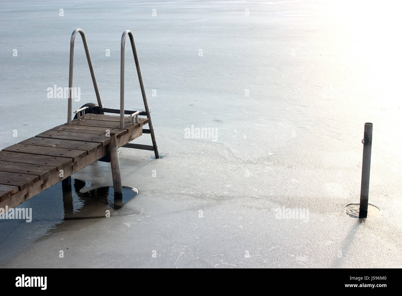 winter wood cold ice bridge frozen steel railing fresh water pond water ...