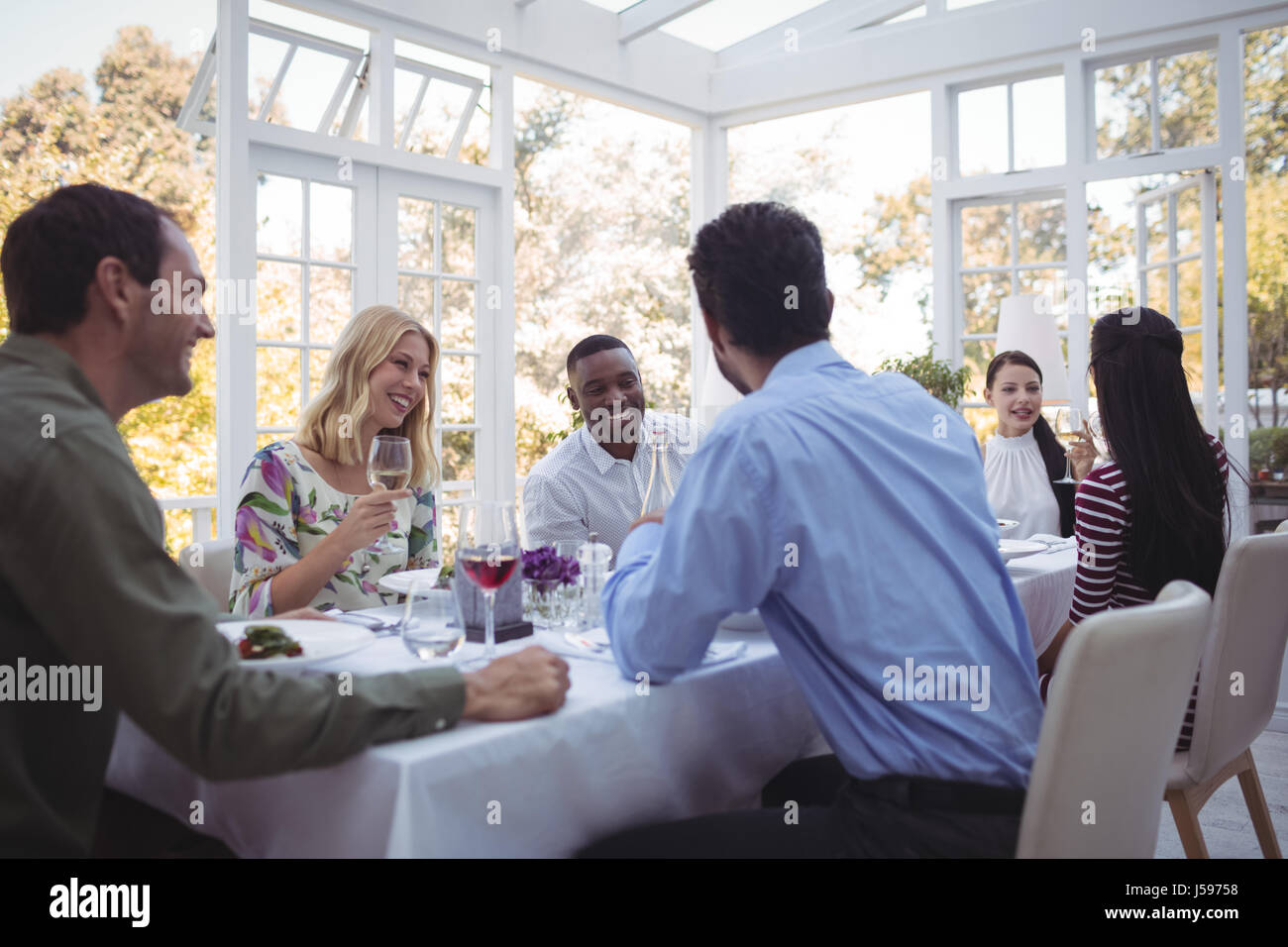 Group of friends interacting with each other while having lunch ...