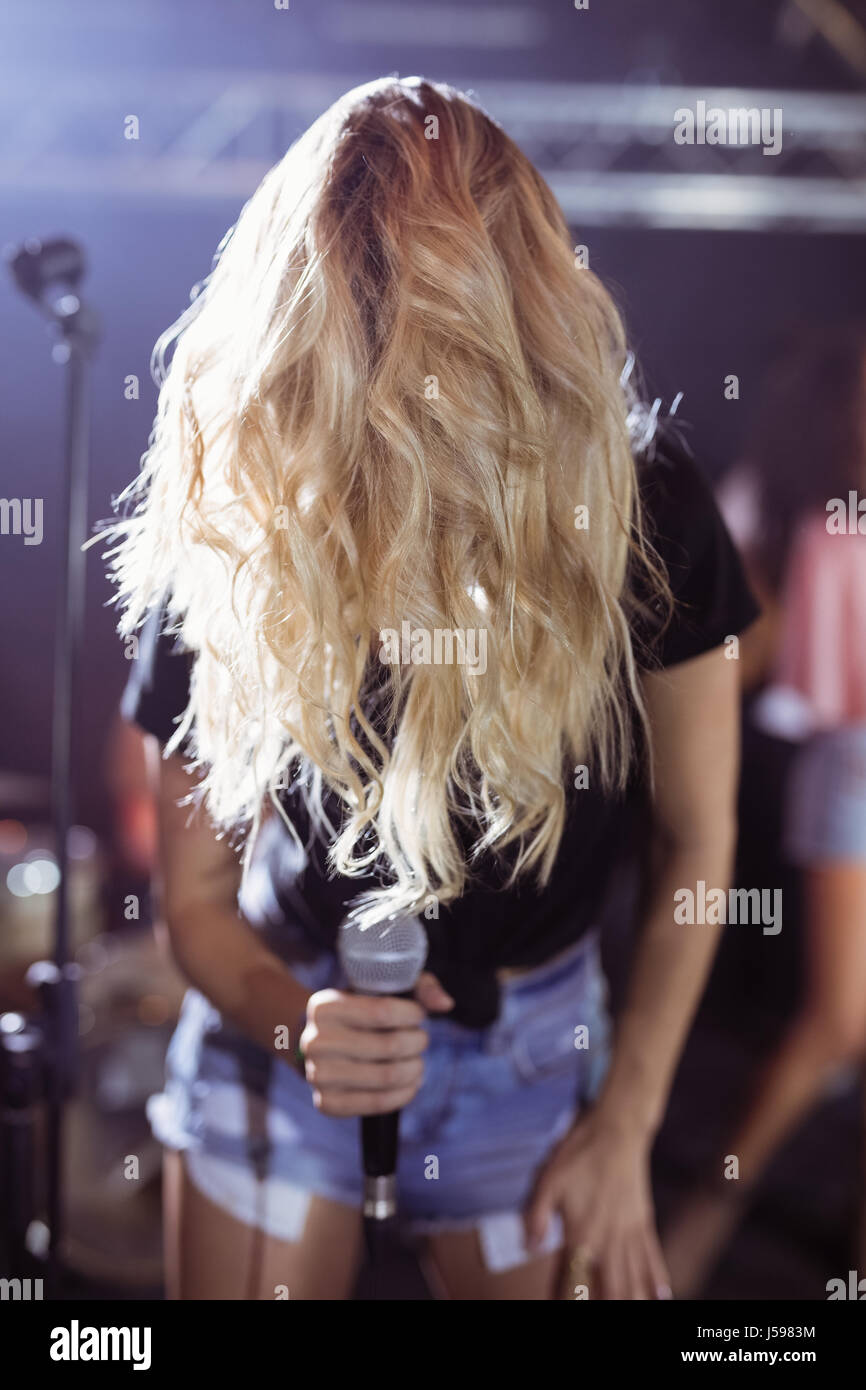 Female singer covering her face with hair while performing at nightclub ...