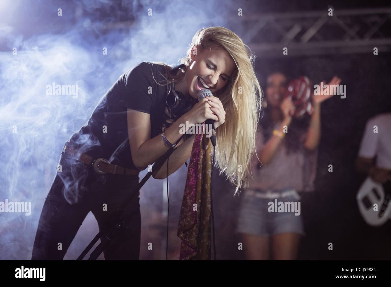 Cheerful female singer performing during music festival at nightclub ...