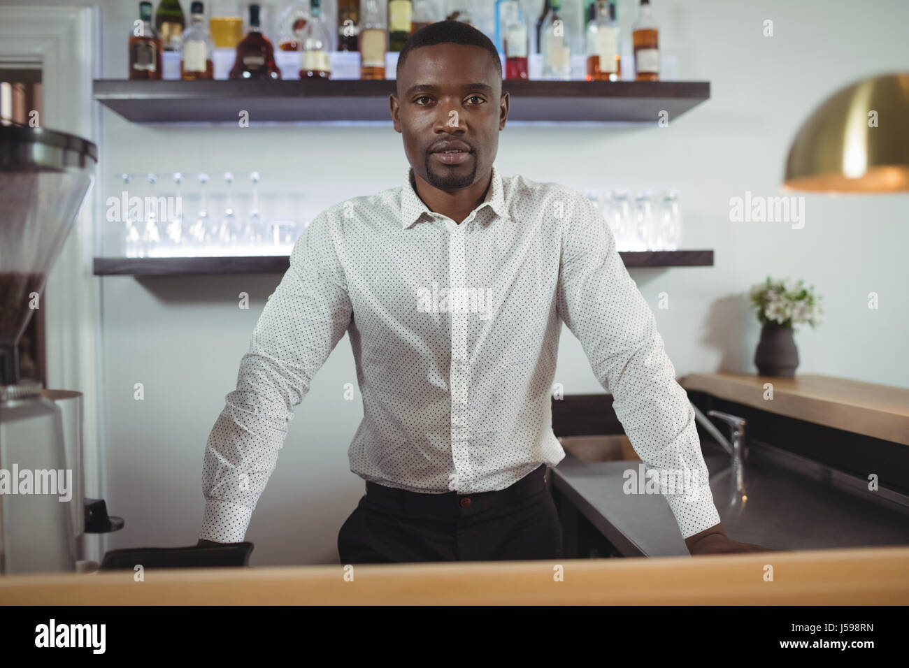 Portrait of bar tender standing at counter in restaurant Stock Photo ...