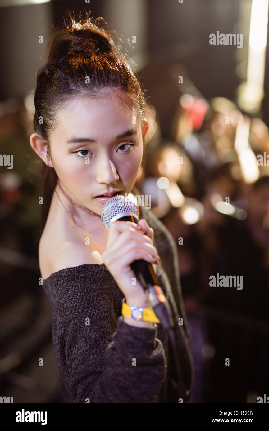 Portrait of young singer performing at music festival in nightclub ...