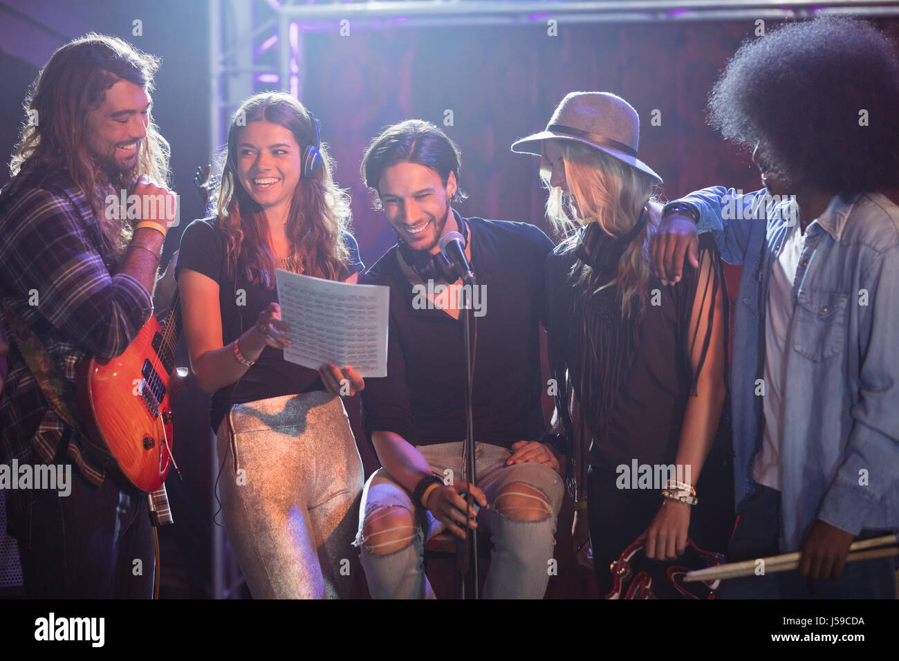 Happy musicians practicing on stage at nightclub before music concert ...