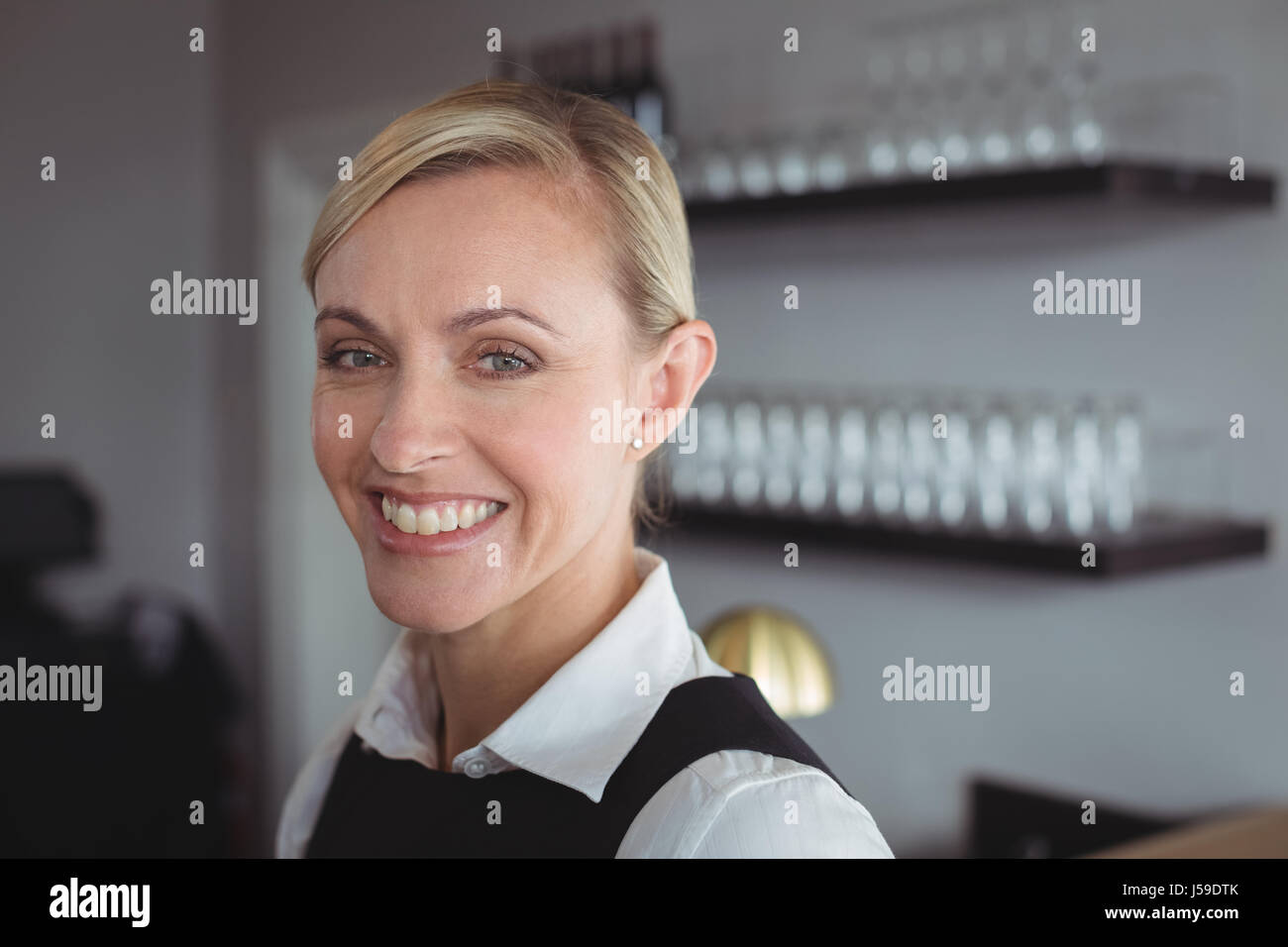 Portrait of smiling waitress in restaurant Stock Photo - Alamy