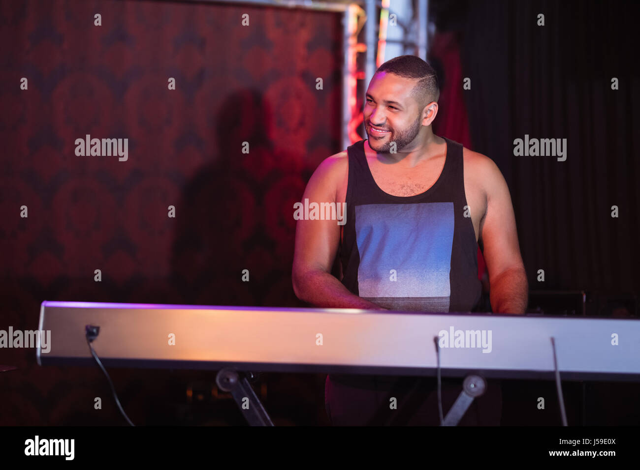 Happy musician playing piano at nightclub during concert Stock Photo ...