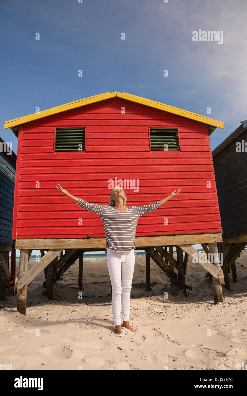 Full length of woman standing on sand against hut at beach Stock Photo ...