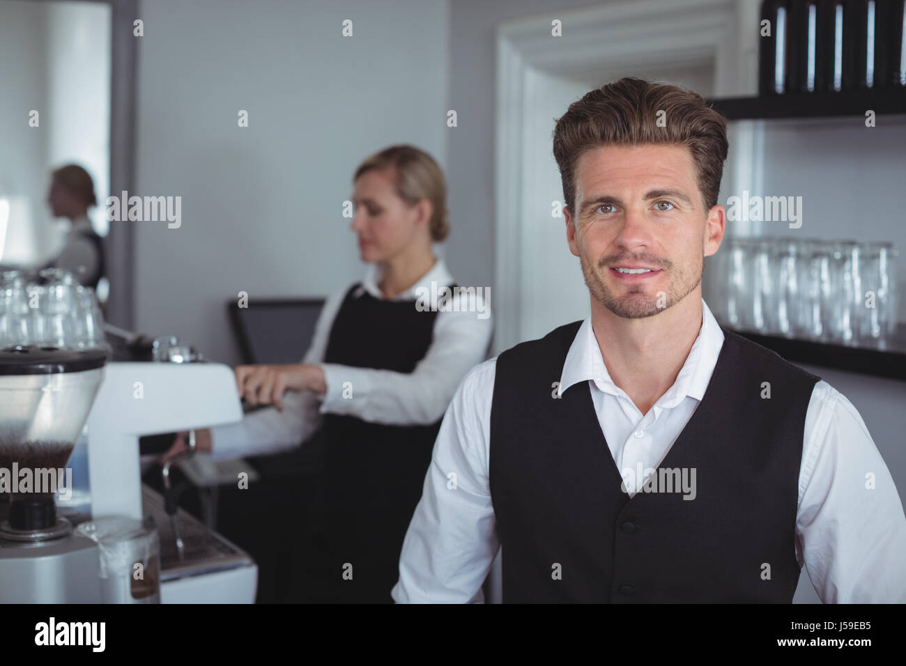 Portrait of waiter smiling at camera in a restaurant Stock Photo - Alamy