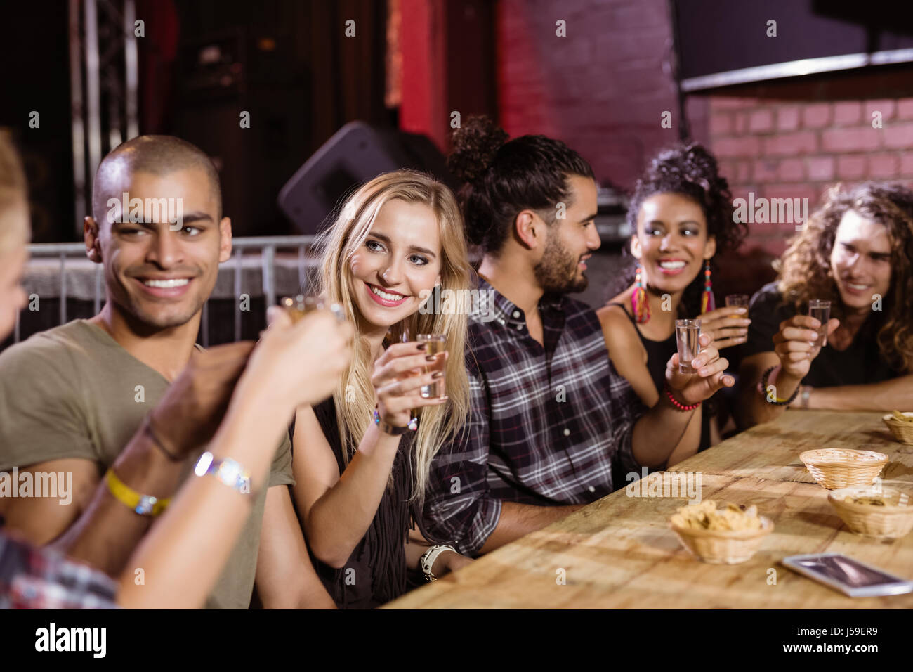 Friends talking while sitting at table in nightclub Stock Photo - Alamy