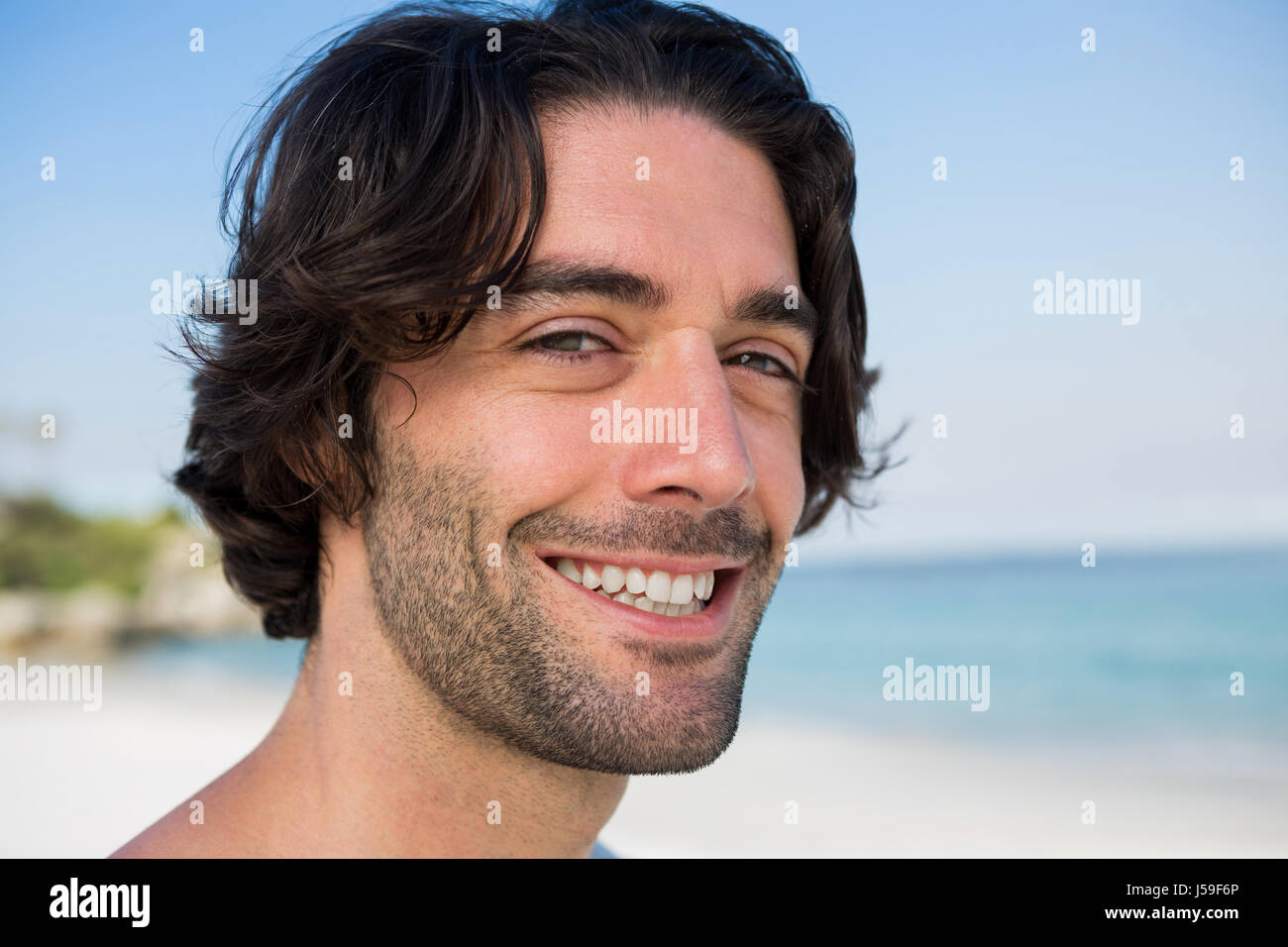 Close up portrait of smiling confident man standing at beach Stock ...
