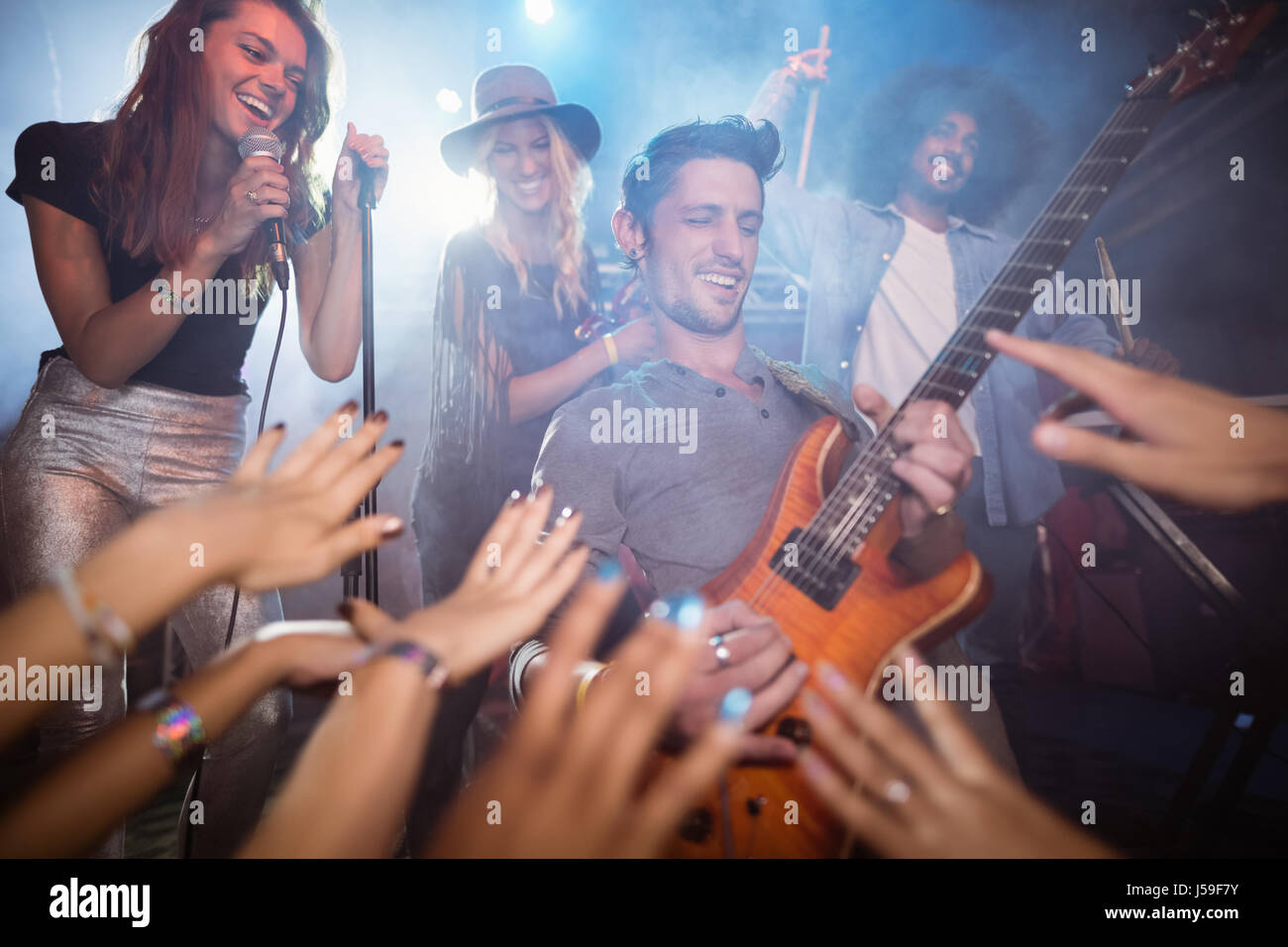 Low angle view of guitarist performing by crowd at nightclub Stock ...