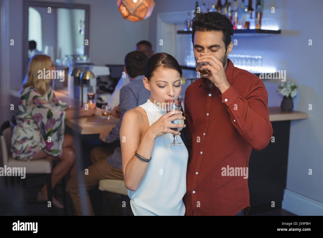 Couple drinking cocktails together in bar restaurant Stock Photo - Alamy