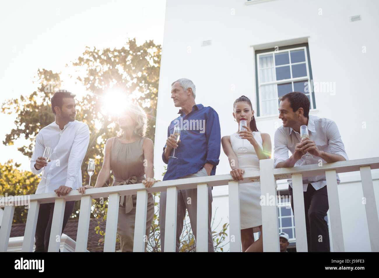 Friends having champagne in balcony at home Stock Photo - Alamy