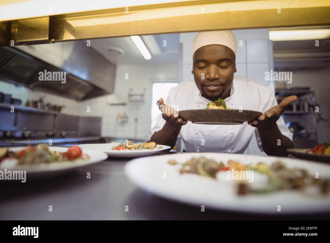 Chef smelling food in commercial kitchen at restaurant Stock Photo - Alamy