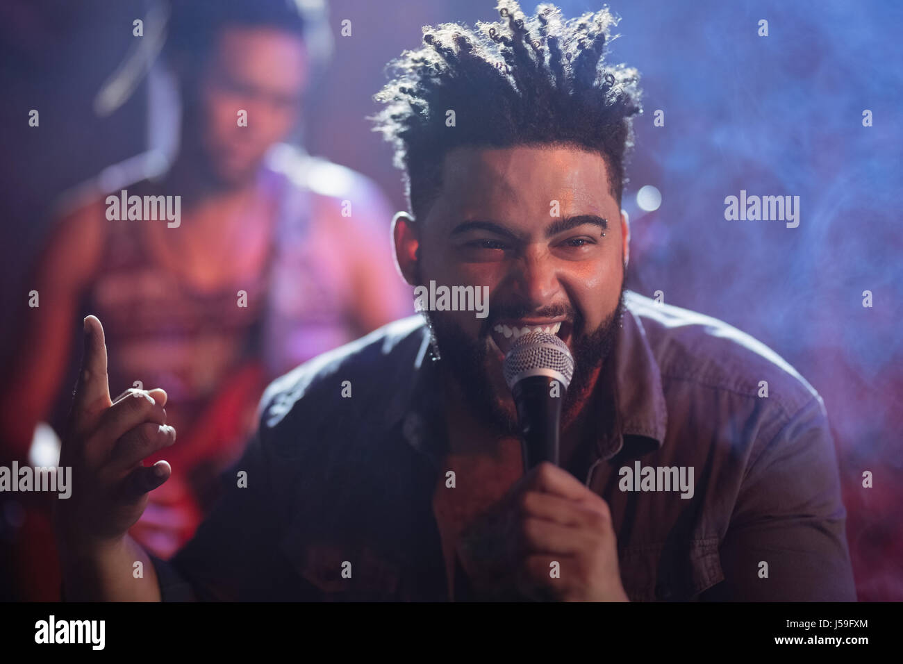 Young singer performing on stage at nightclub during music festival ...