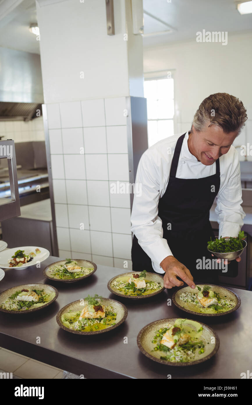 Male chef garnishing appetizer in plate at order station Stock Photo ...