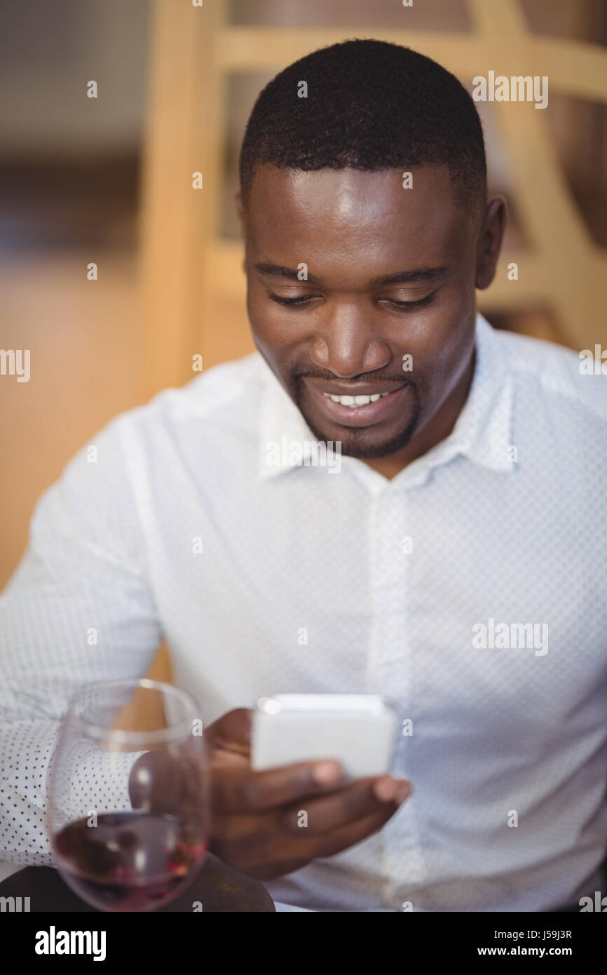 Happy man using mobile phone in restaurant Stock Photo - Alamy