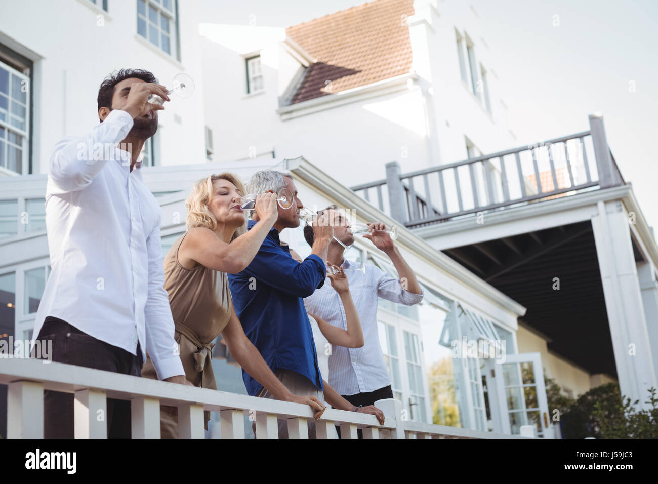 Friends having champagne in balcony at home Stock Photo - Alamy