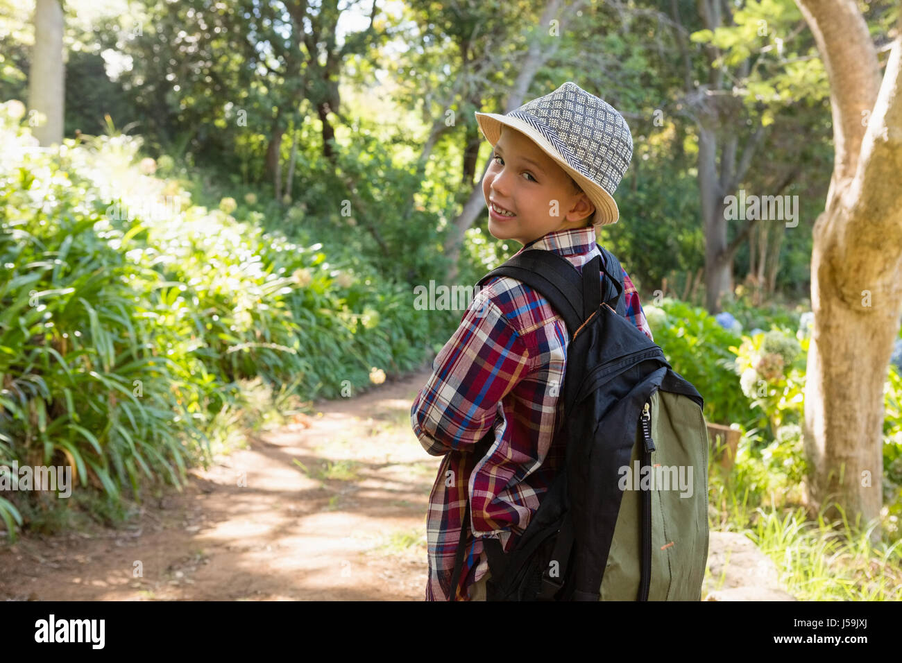 Smiling boy looking behind in the forest Stock Photo - Alamy