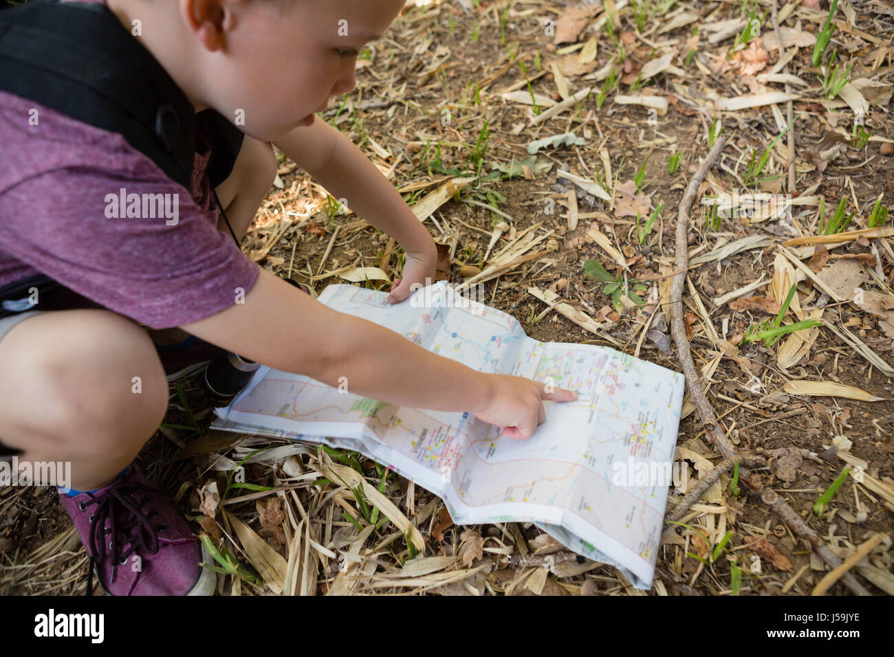 Cute boy reading the map in the forest Stock Photo - Alamy