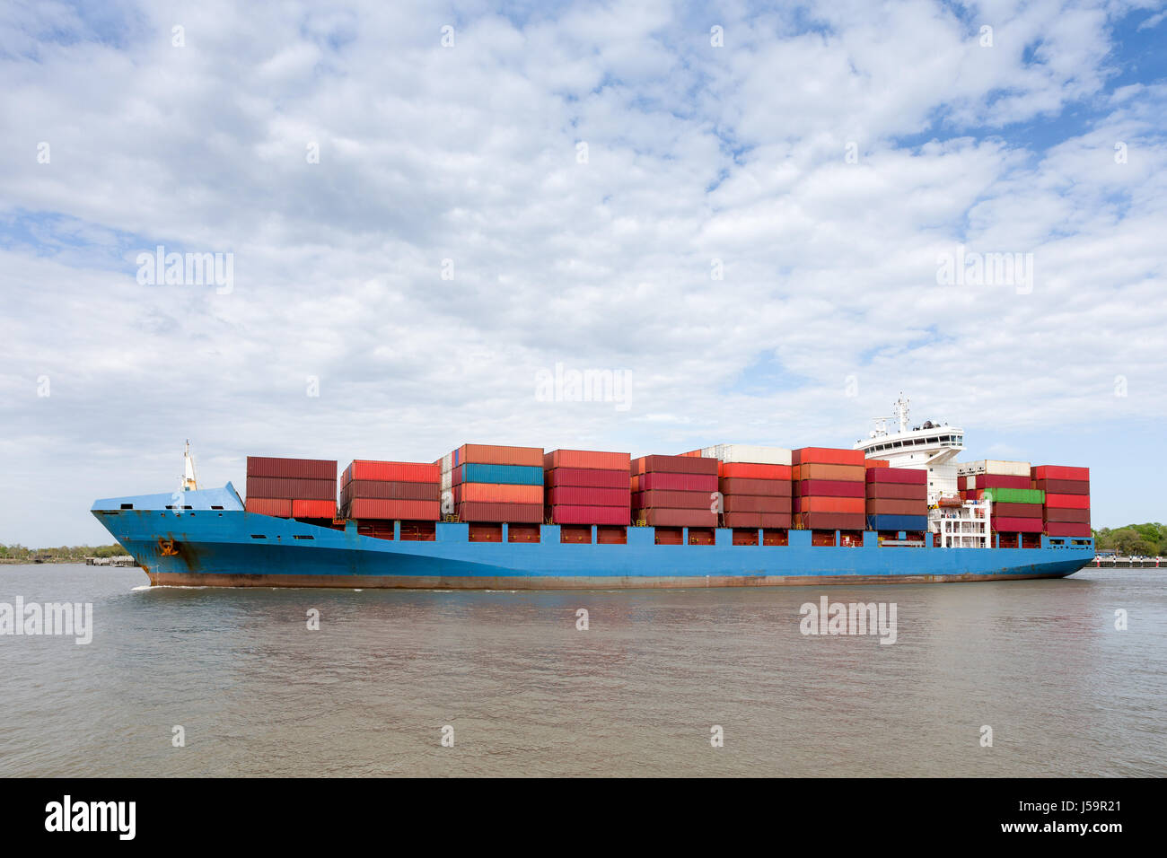 Dramatic view of a fully loaded cargo container ship returning to port ...