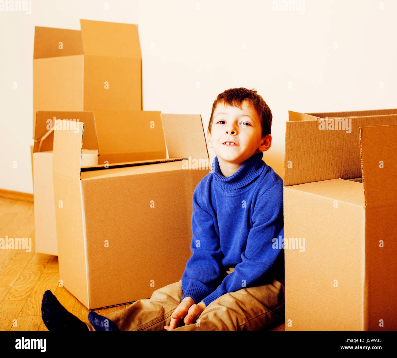 little cute boy in empty room, remoove to new house. home alone emong ...