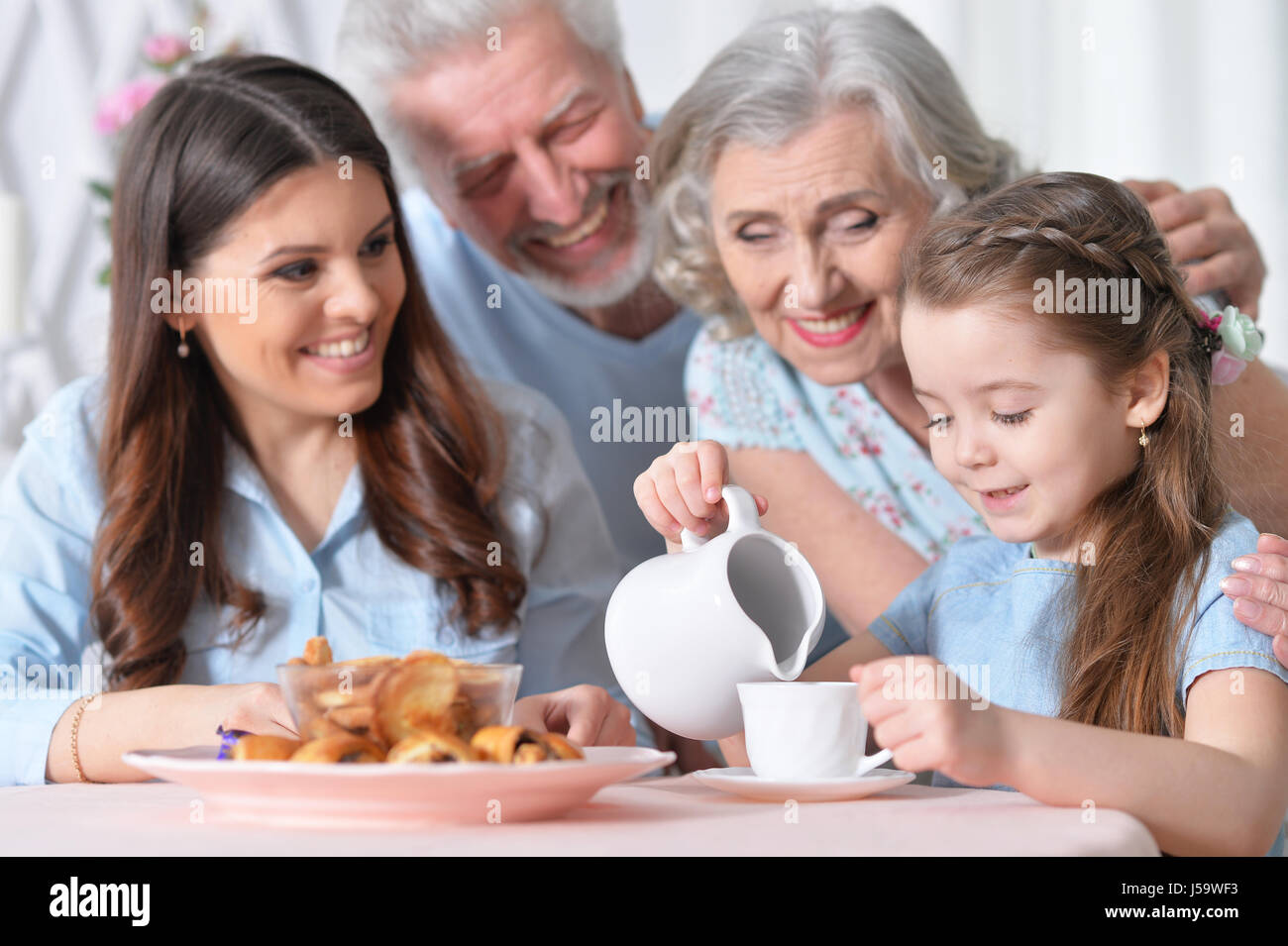 Beautiful happy family drinking tea Stock Photo - Alamy