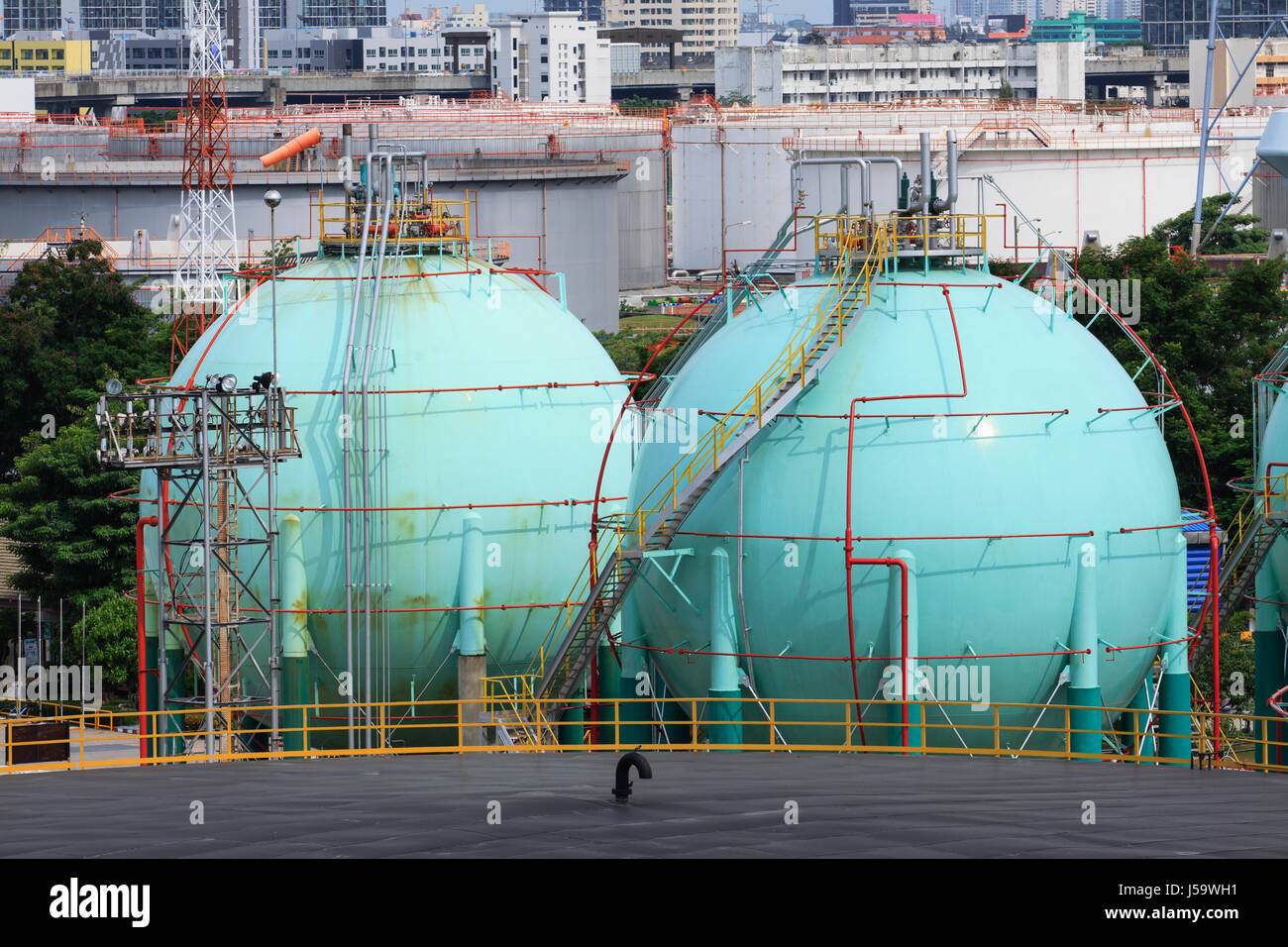 gas storage tank in oil refinery industry site with urban scen ...