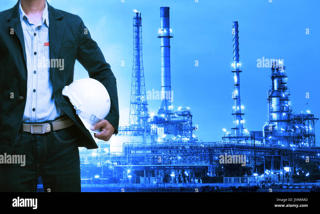 engineering man and safety helmet standing against oil refinery plant ...