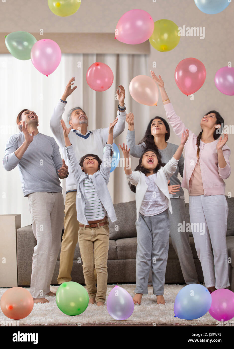 Multi-generation family playing with balloons Stock Photo - Alamy