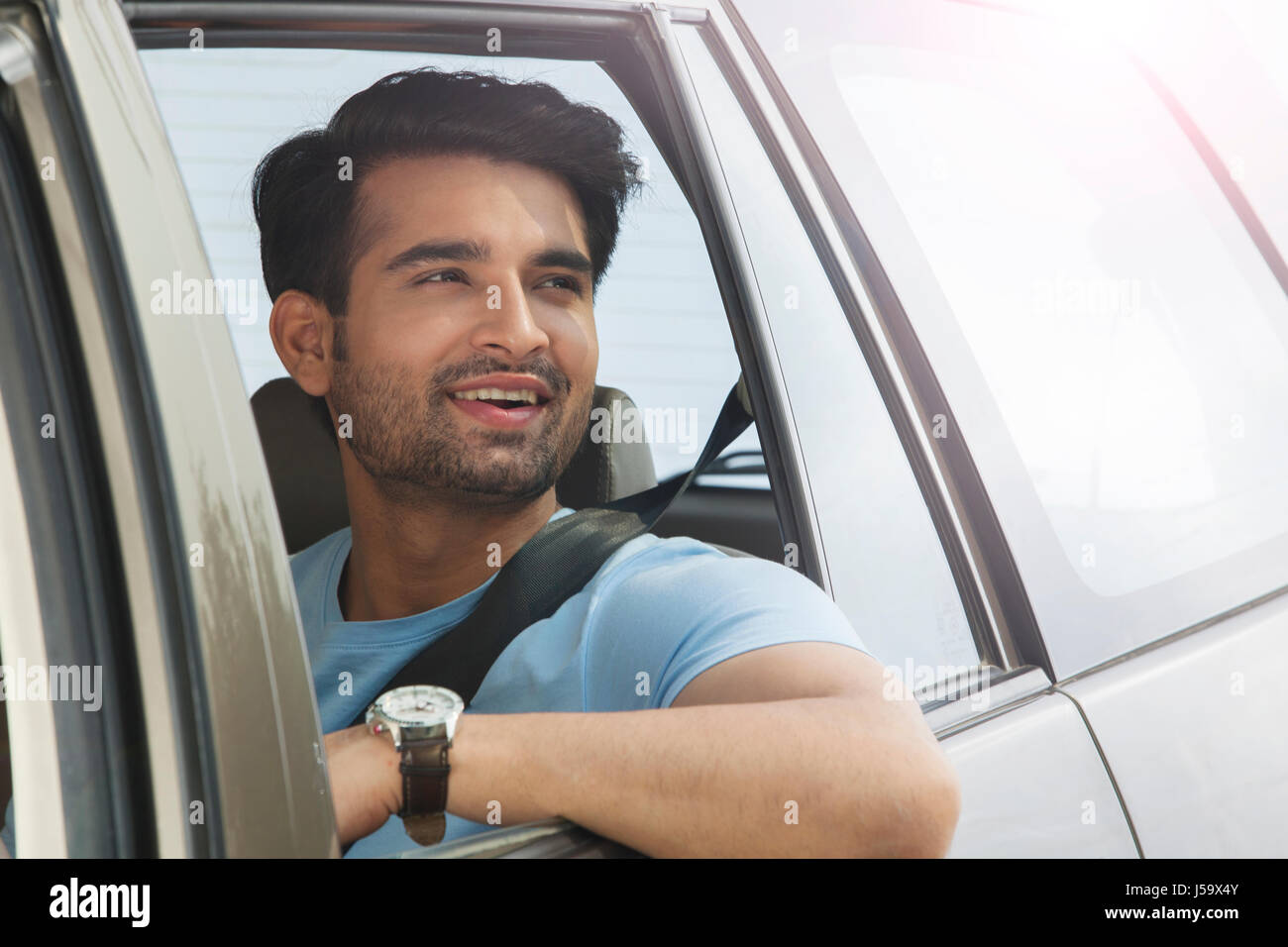 Young man looking out of car window Stock Photo - Alamy