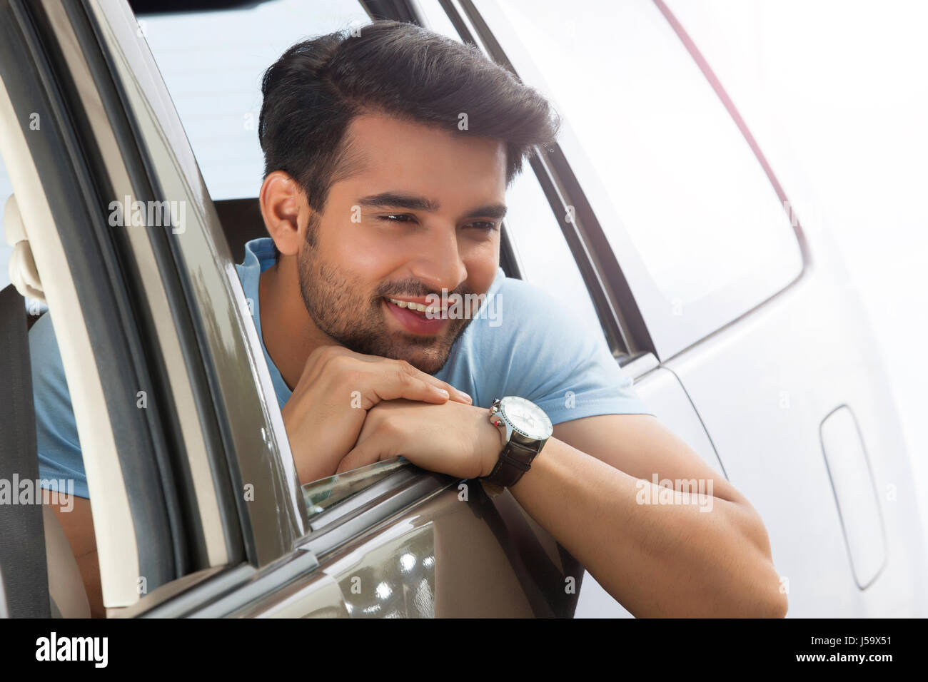 Young man looking out of car window Stock Photo - Alamy