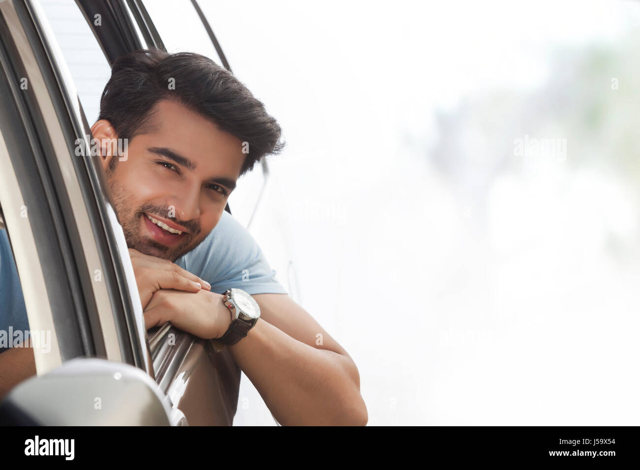 Young man looking out of car window Stock Photo - Alamy
