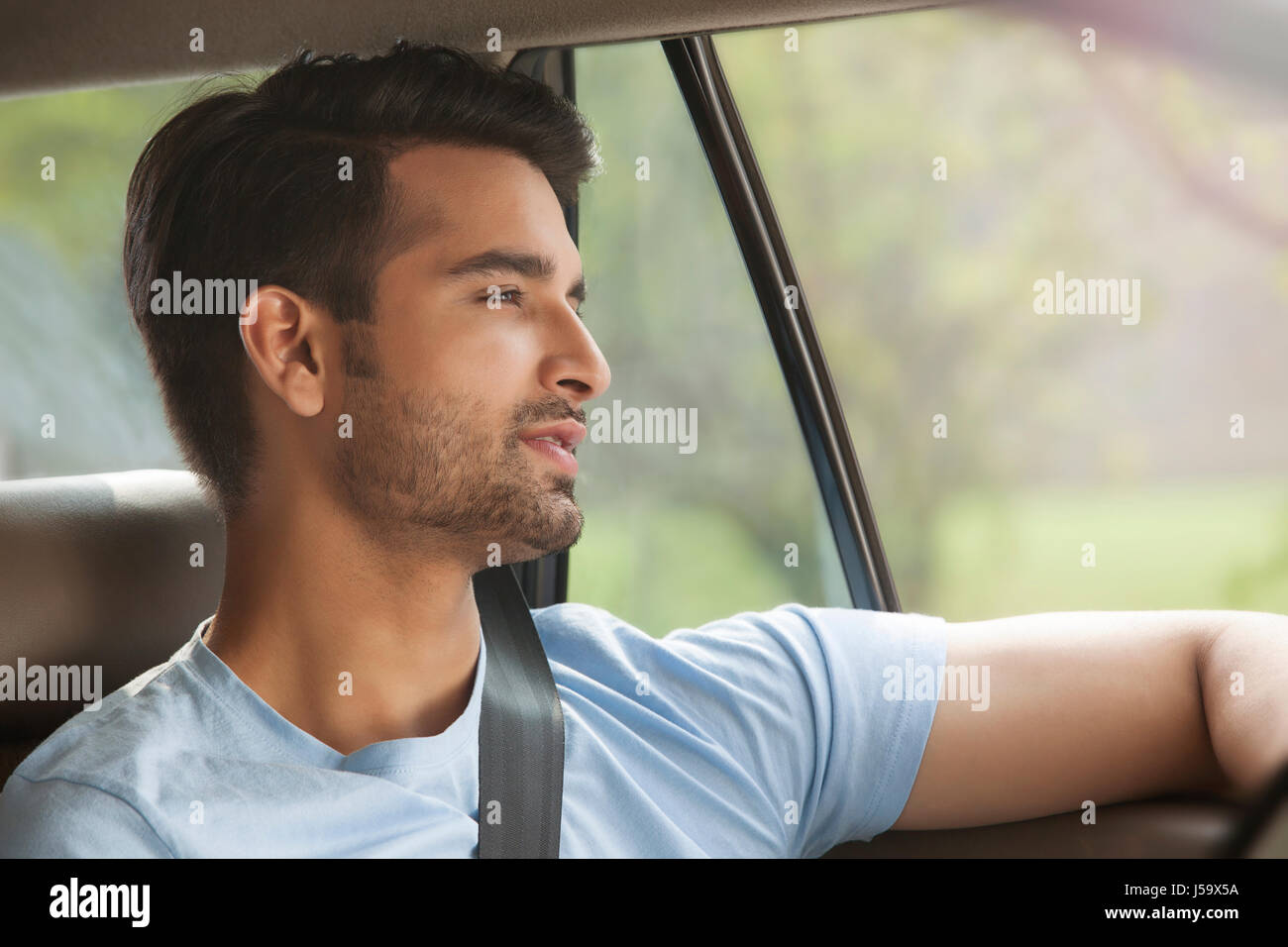 Young man looking out of car window Stock Photo - Alamy