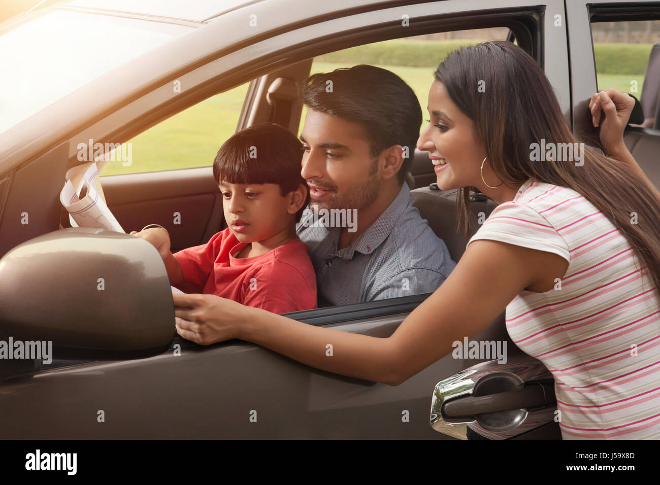 Family looking at map while on road trip Stock Photo - Alamy