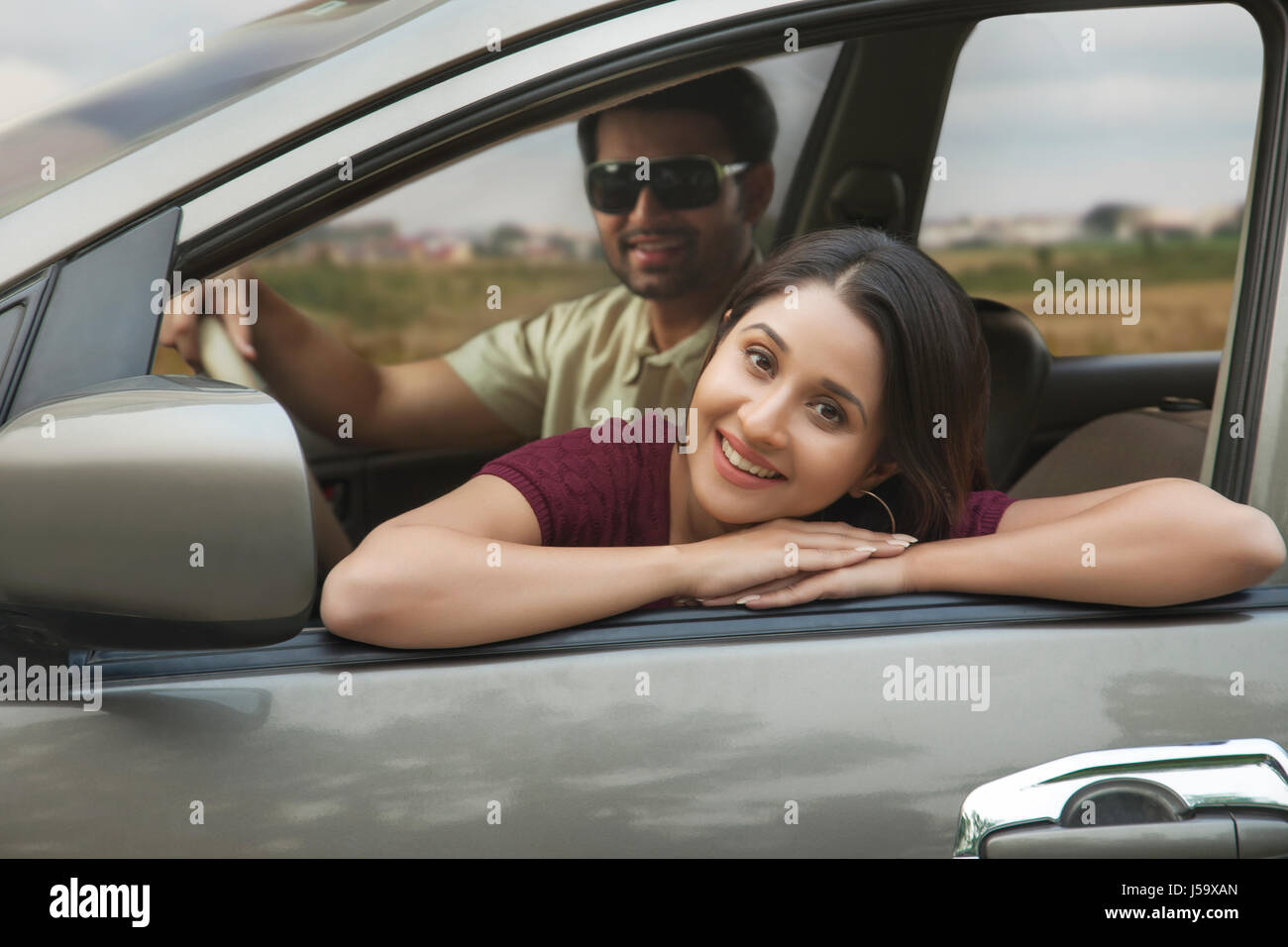 Young woman relaxing on car door during car ride Stock Photo - Alamy