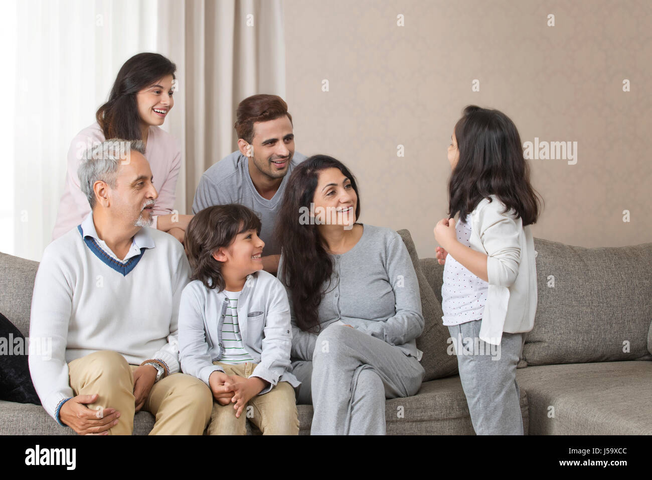 Happy multi-generation family sitting together on sofa Stock Photo - Alamy