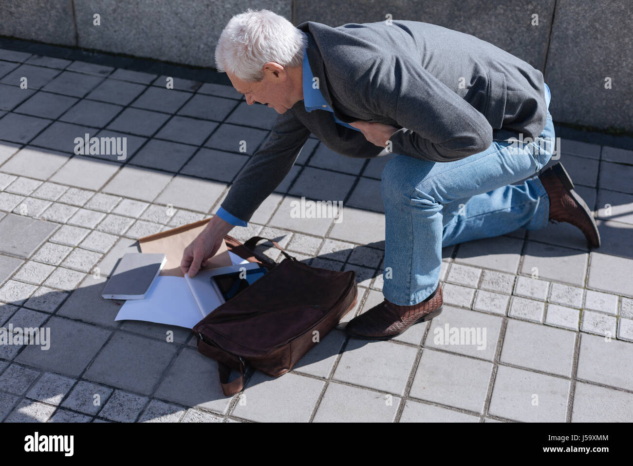 Awkward pensioner dropping bag from his hand outdoors Stock Photo - Alamy