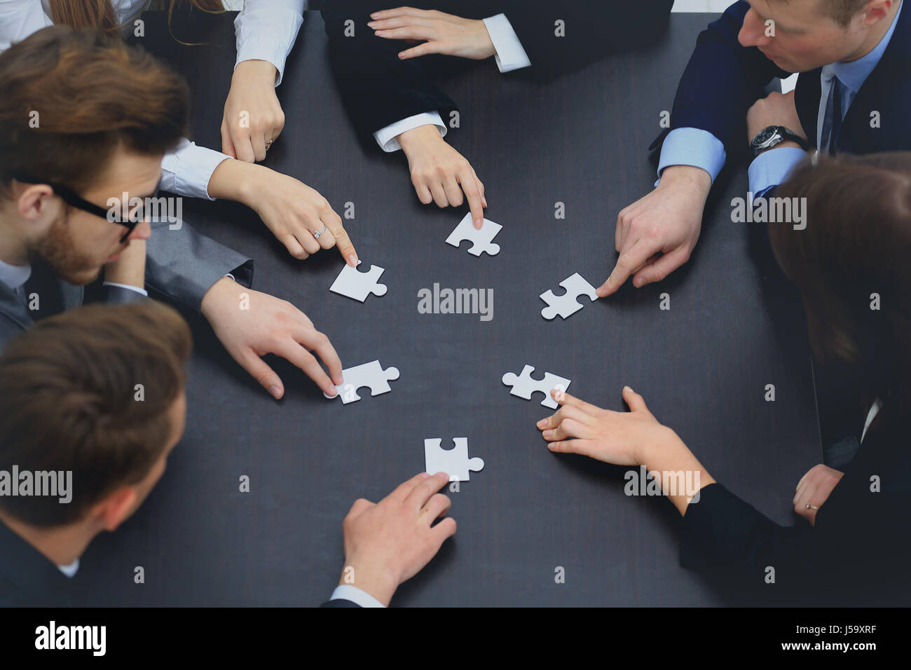 business team solving puzzle together Stock Photo - Alamy