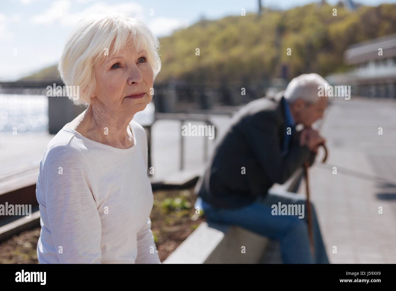 Relaxed old woman expressing sadness in the open air Stock Photo - Alamy