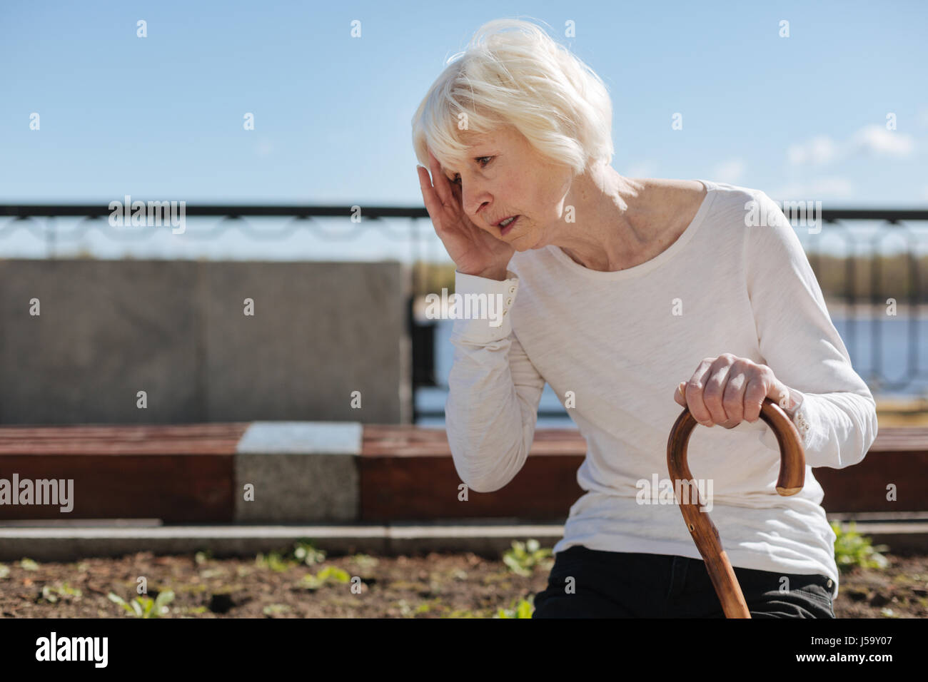 Distressed lady feeling headache in the park Stock Photo - Alamy