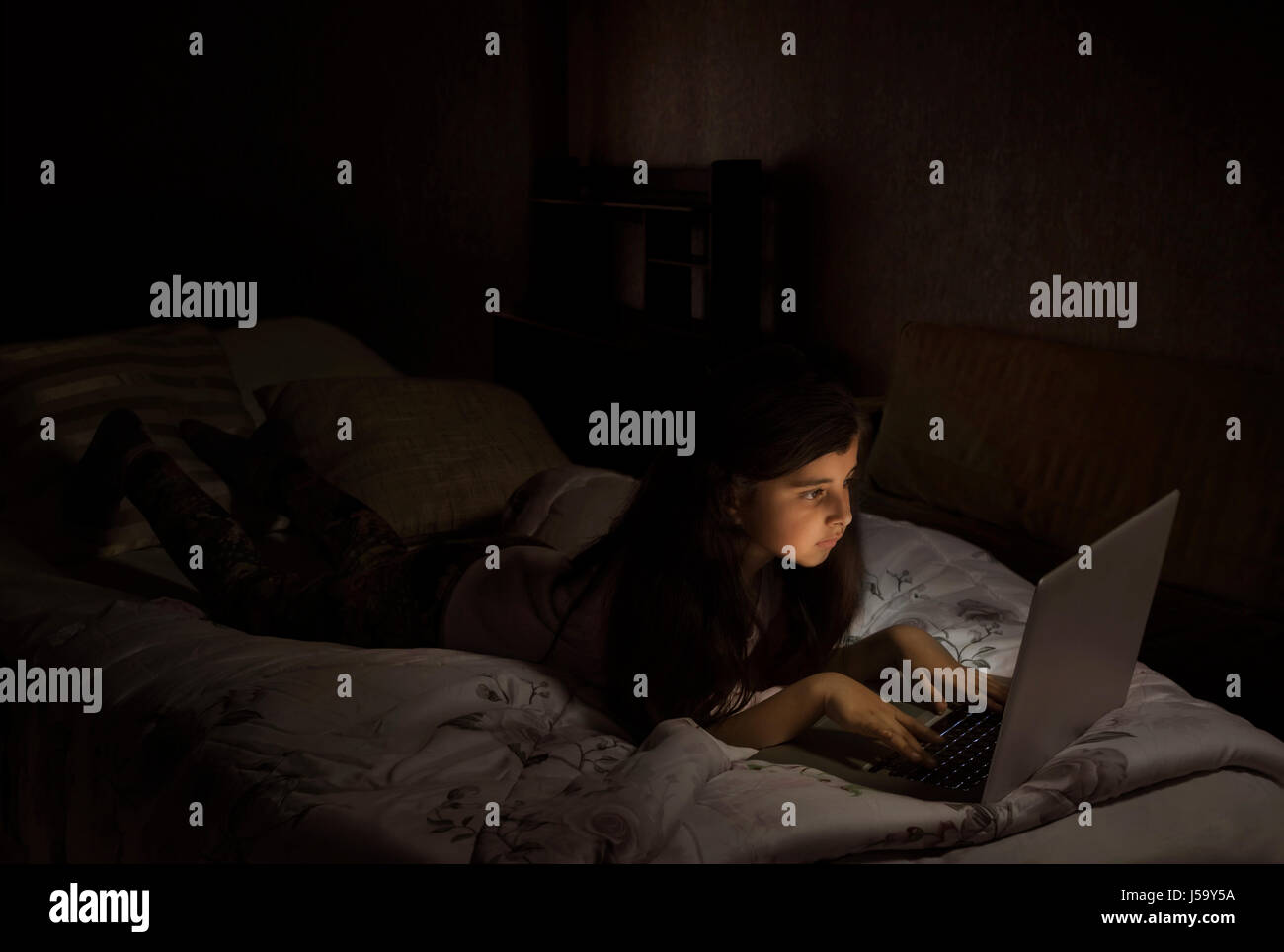 Little girl using a laptop computer in her bedroom at night Stock Photo ...