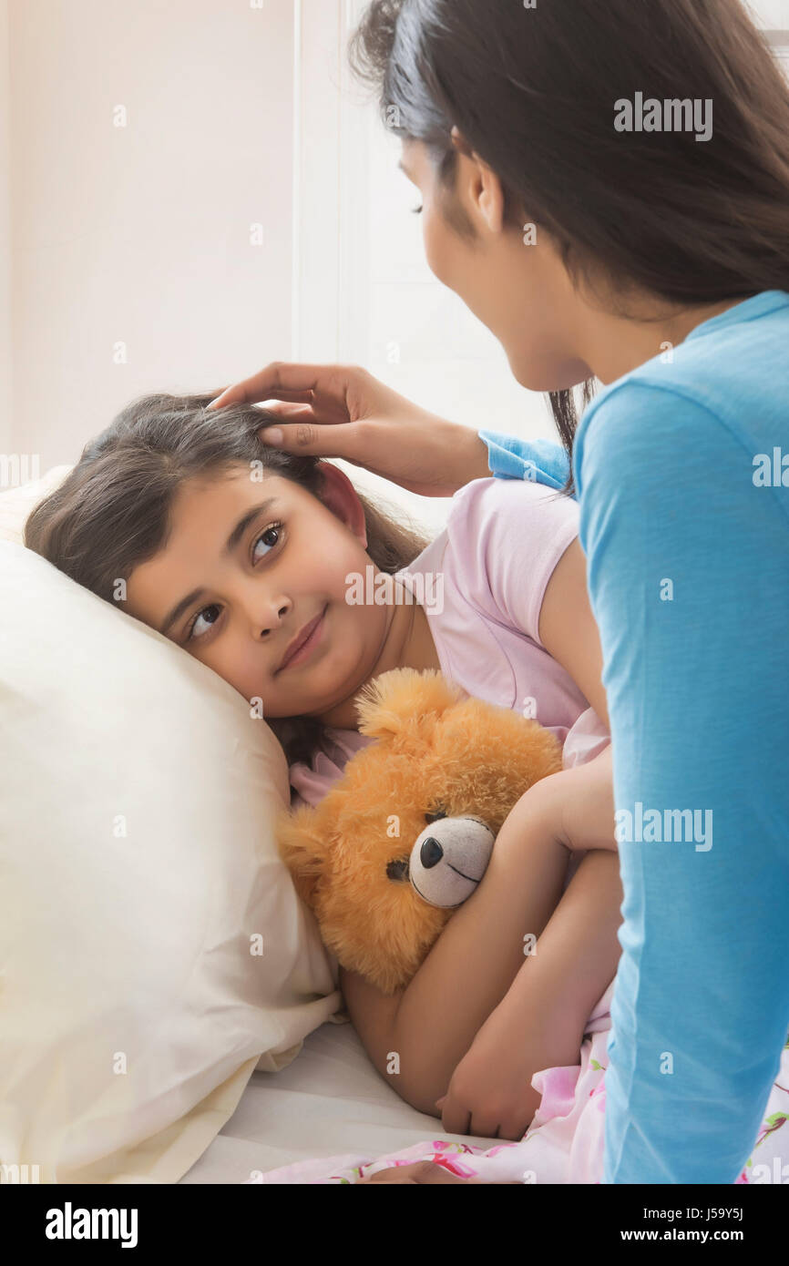 Mother pampering daughter in bed Stock Photo - Alamy