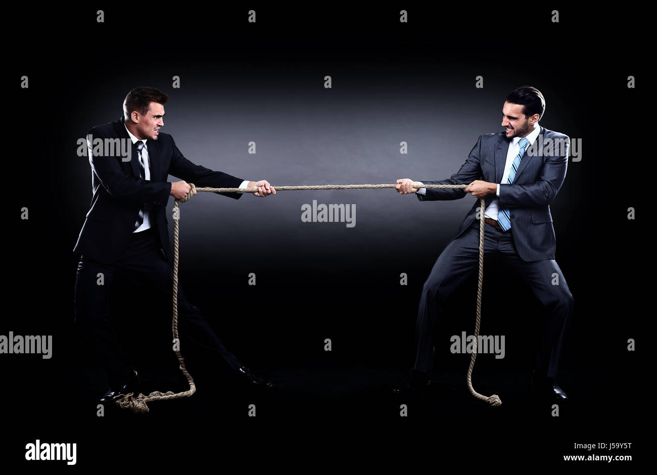 Two business men pulling rope in a competition, isolated on white ...