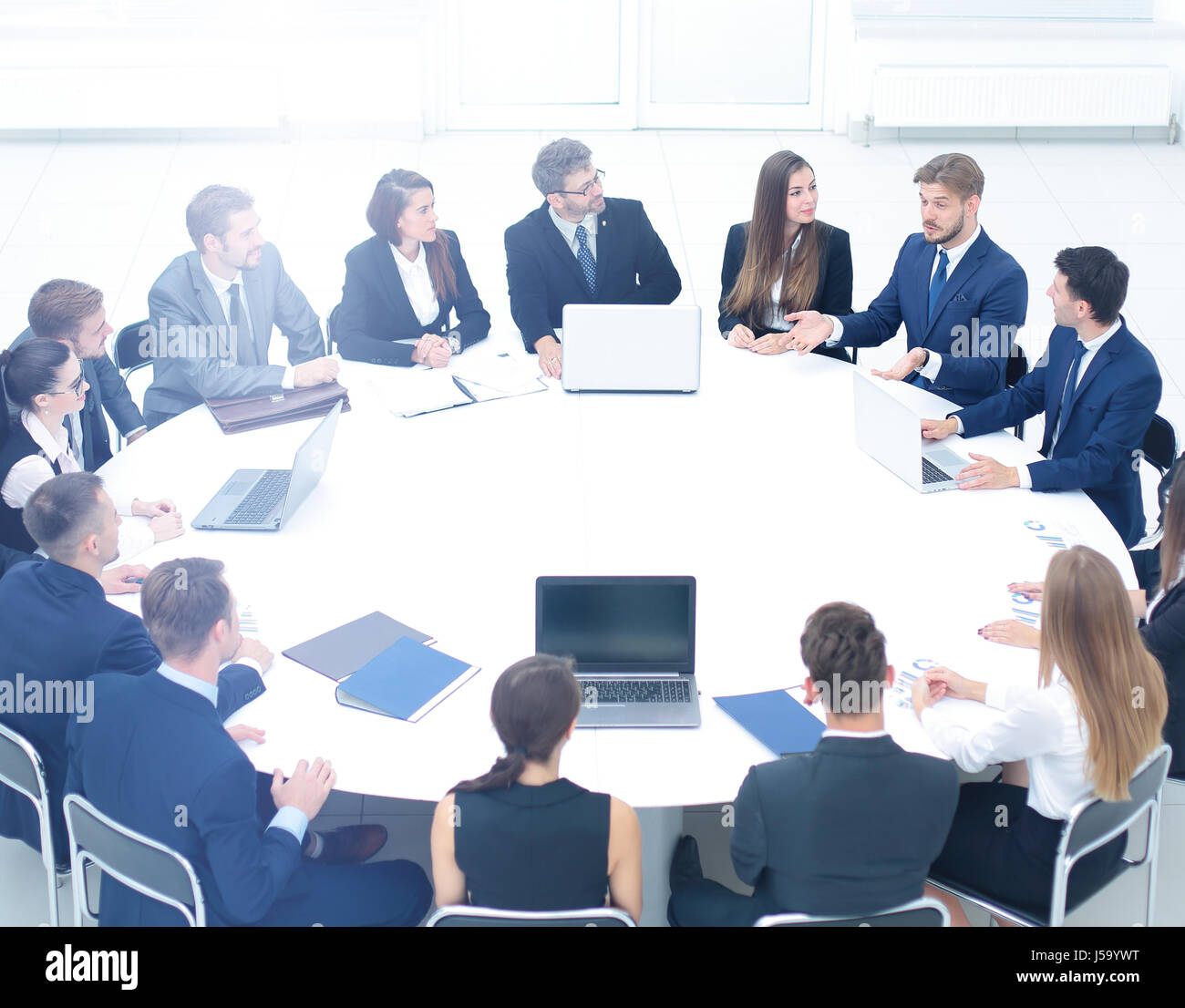 employee makes a report on the seminar held at a large round table in ...