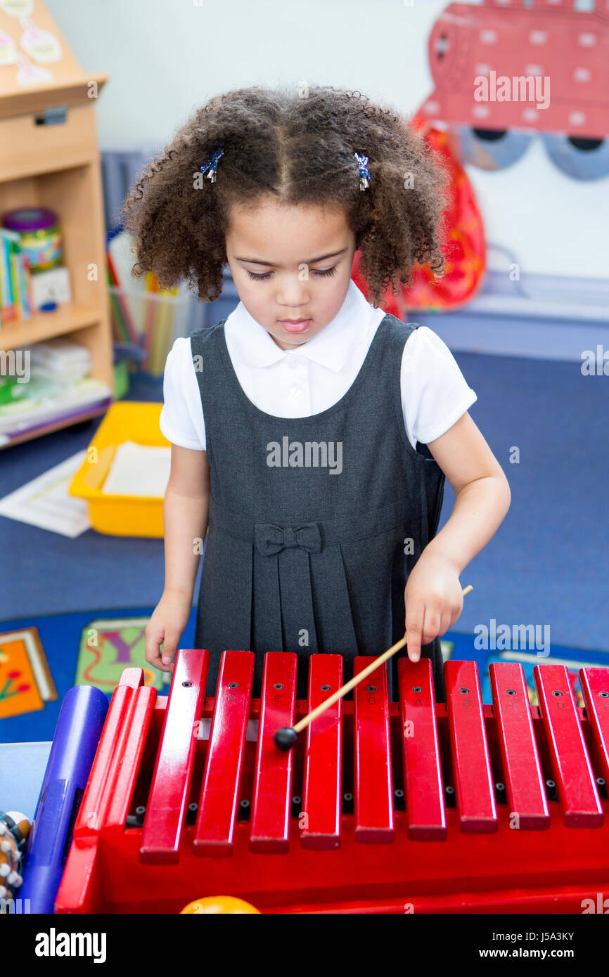 Little girl playing on a xylophone in a nursery classroom Stock Photo ...