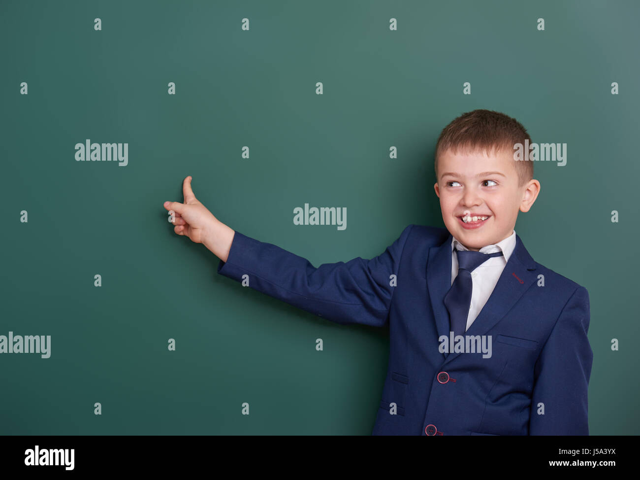 school boy point the finger near blank chalkboard background, dressed ...